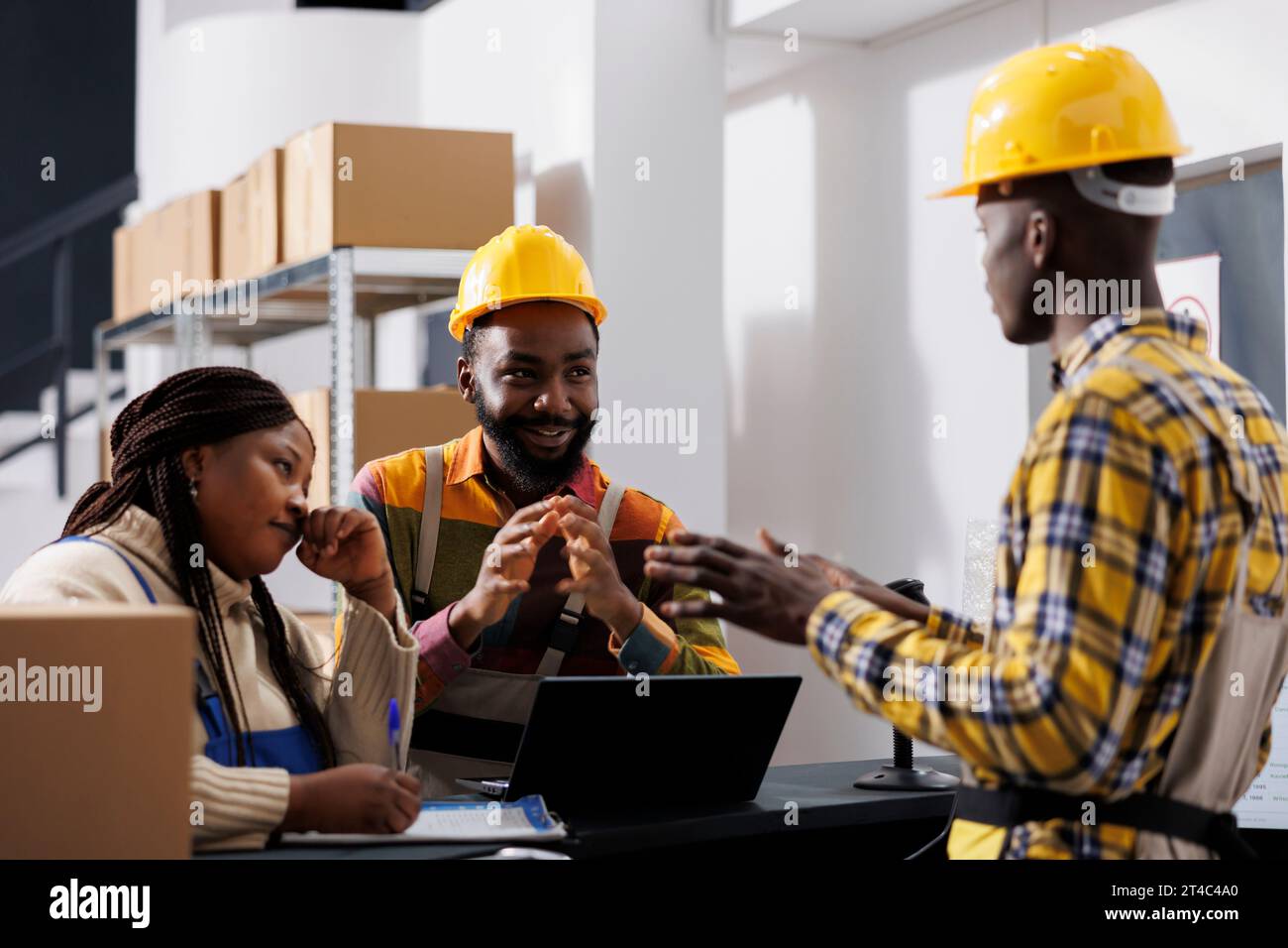African american postal warehouse coworkers chatting at reception desk. Storehouse package ...