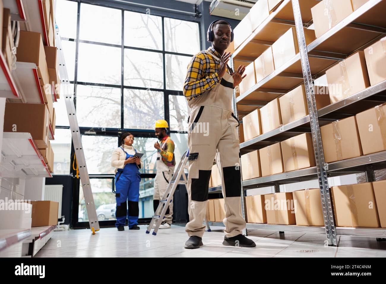 African american man in headphones dancing in parcels storage room ...