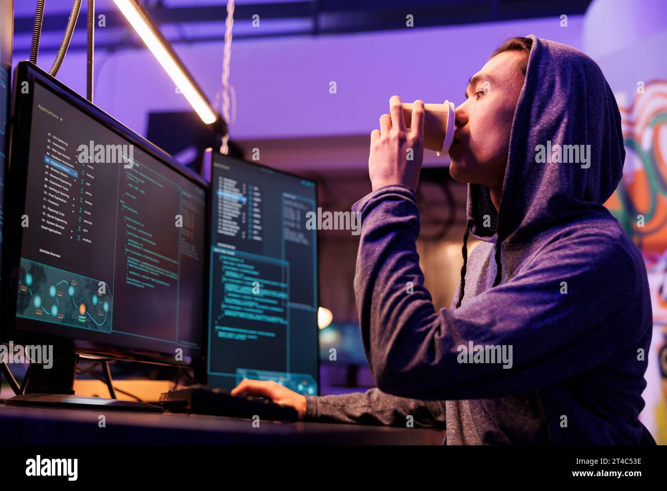 Hacker breaking website on computer while drinking coffee to go. Young ...