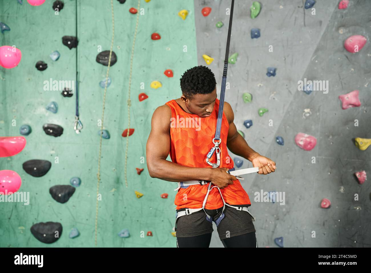 good looking african american man in orange shirt checking his alpine ...