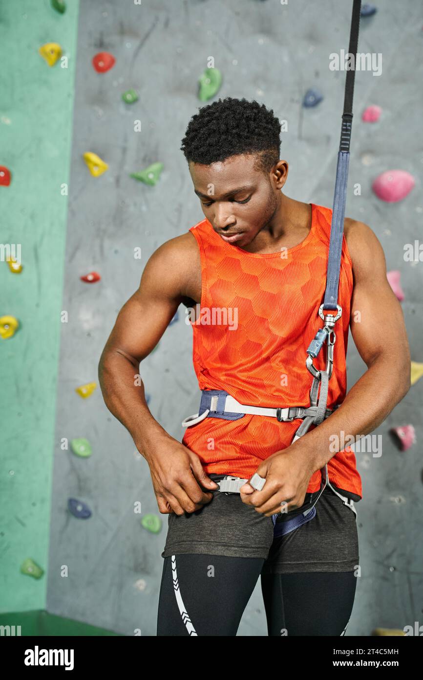 handsome young african american man checking his safety rope before ...