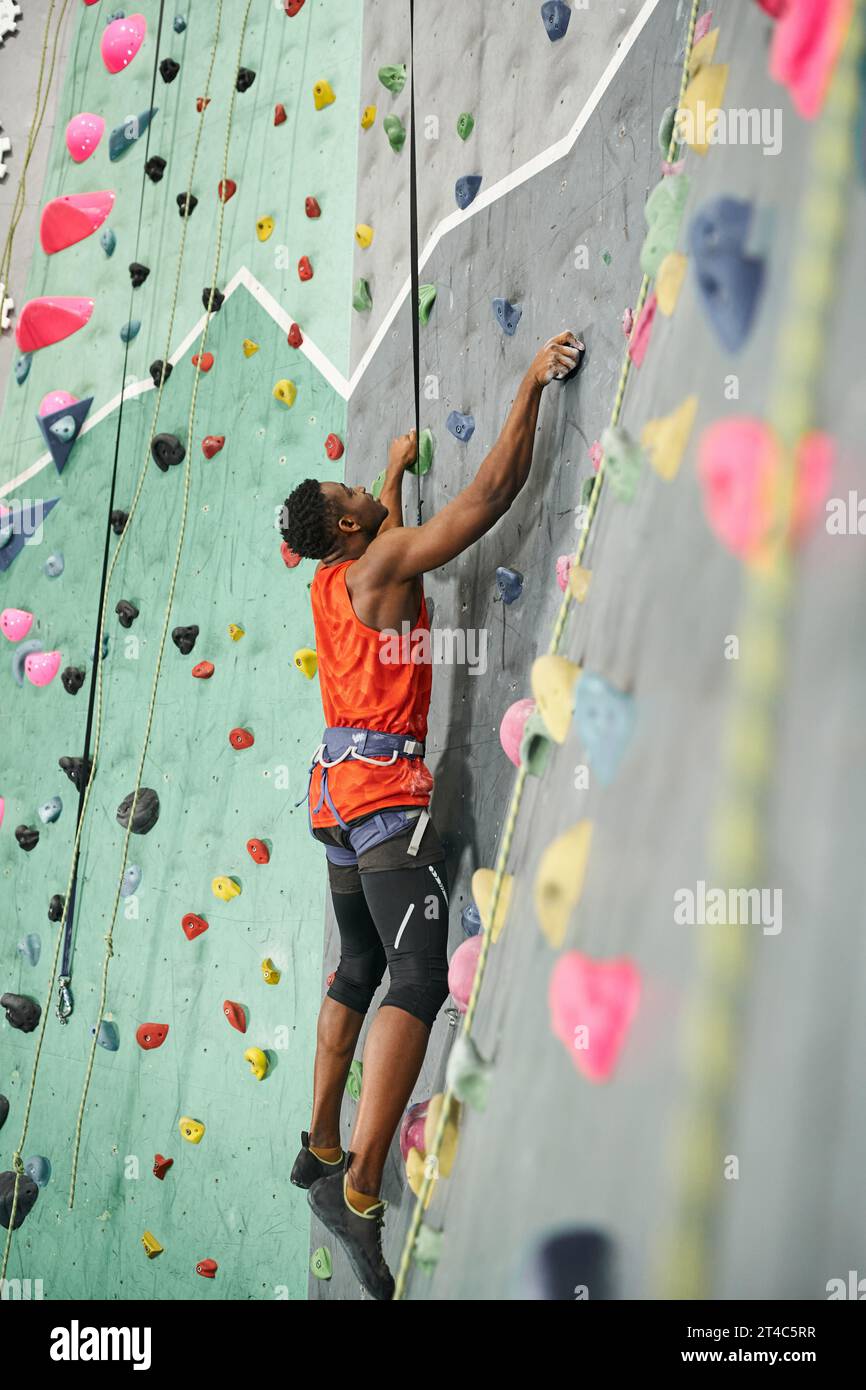 handsome muscular african american man gripping on boulders while ...