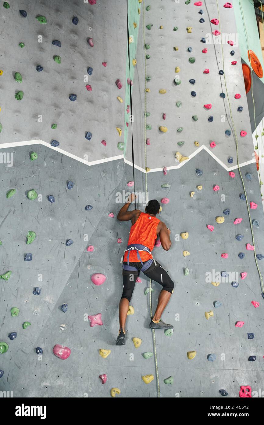 back view of athletic african american man with alpine harness and ...