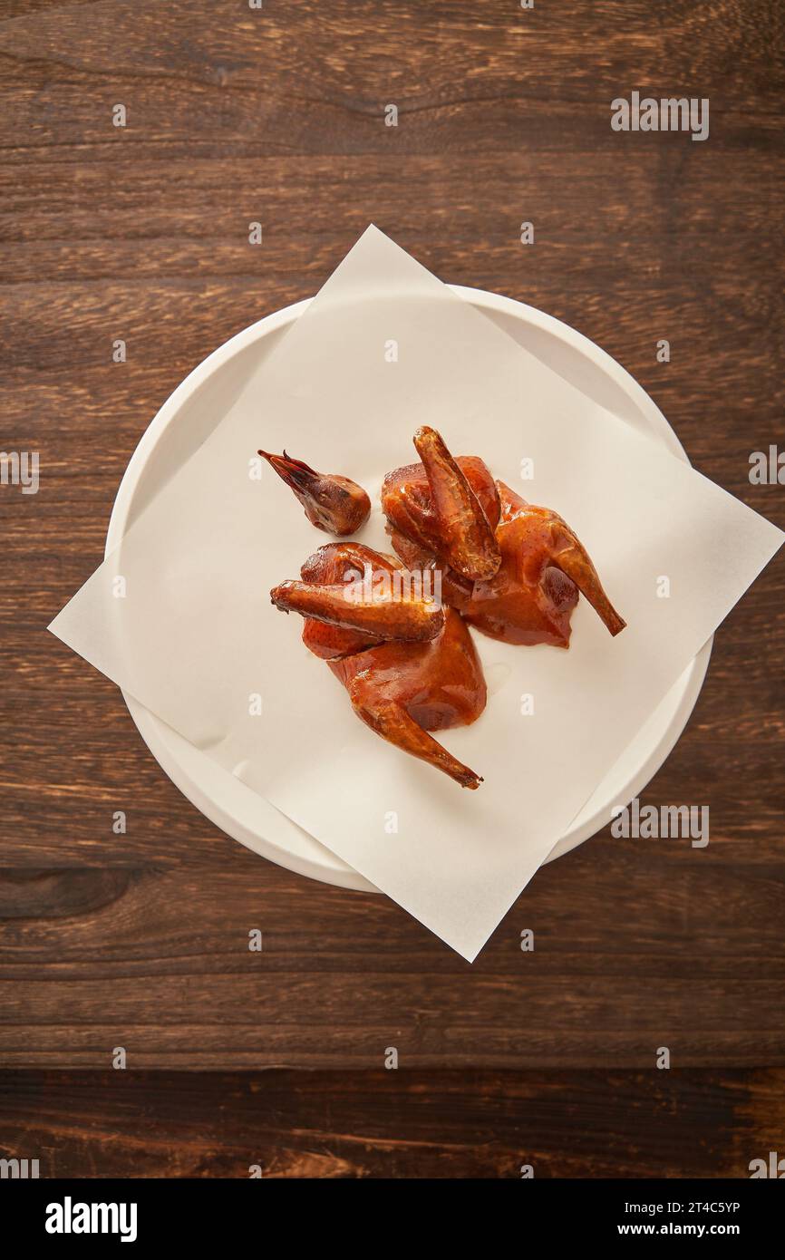 Traditional Cantonese grilled pigeon on a white porcelain plate，Crispy ...