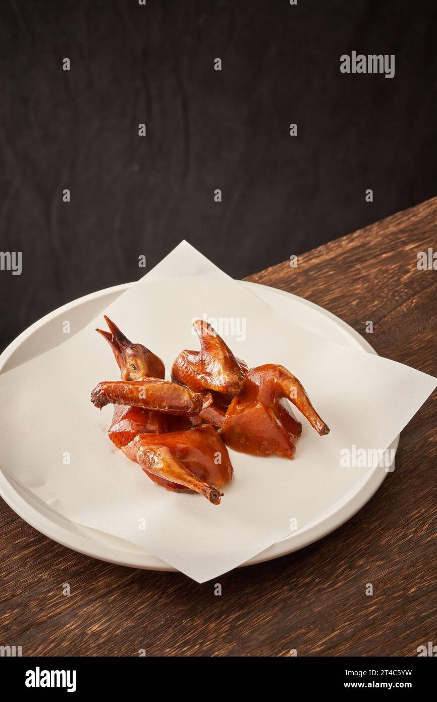 Traditional Cantonese grilled pigeon on a white porcelain plate，Crispy ...