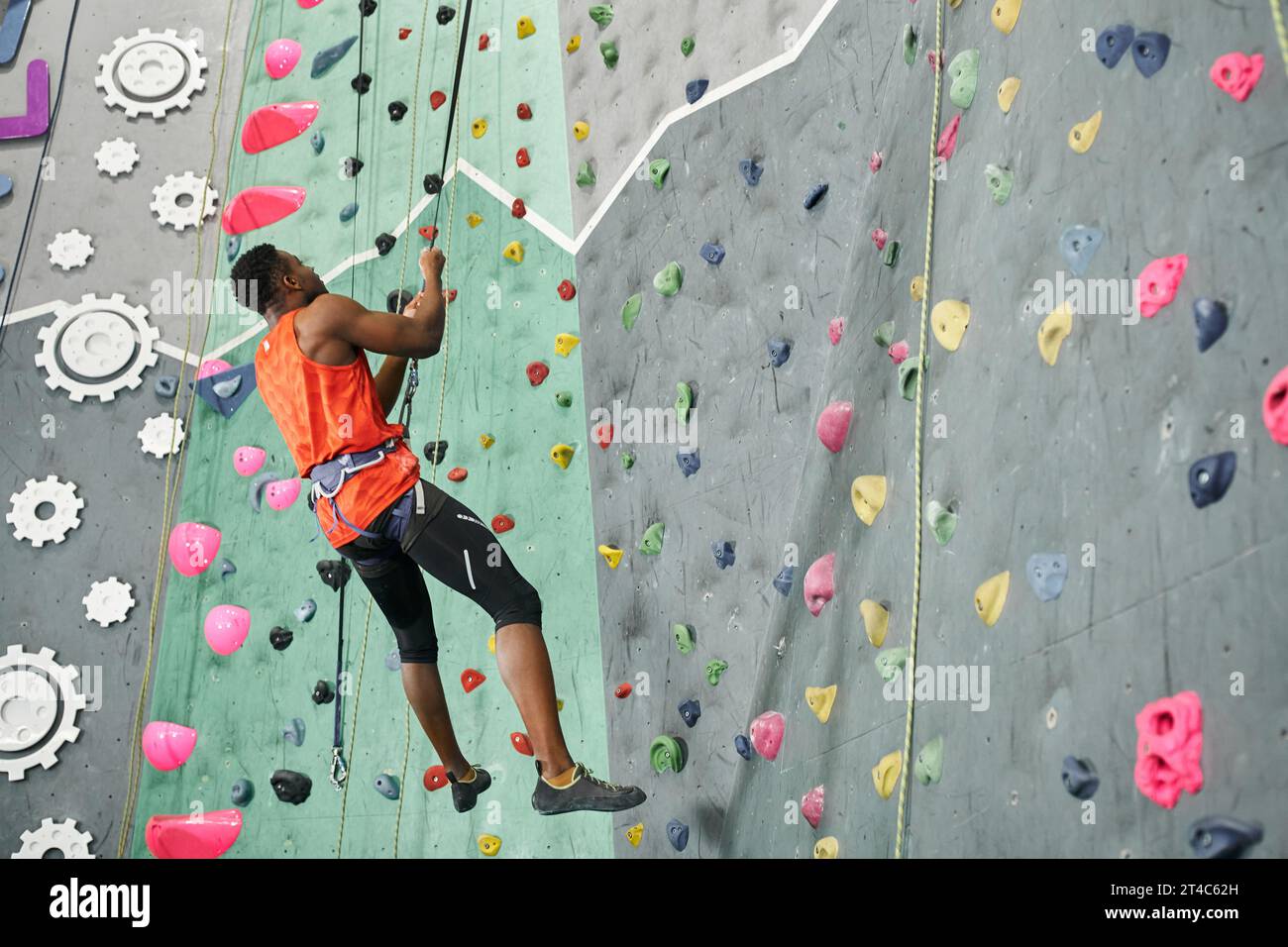 young sporty african american man with alpine harness hanging on his ...