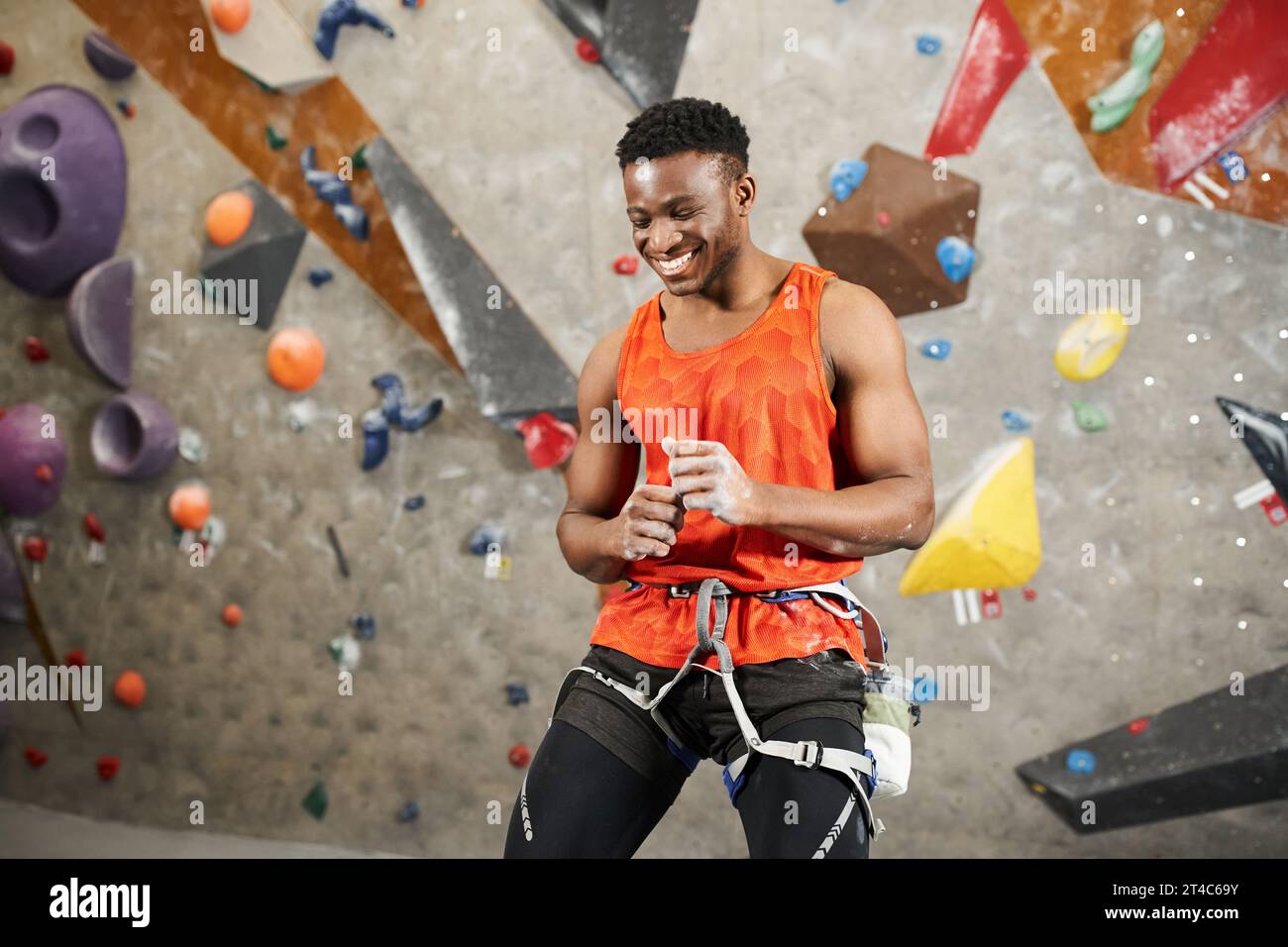 cheerful african american man in orange shirt laughing sincerely posing ...