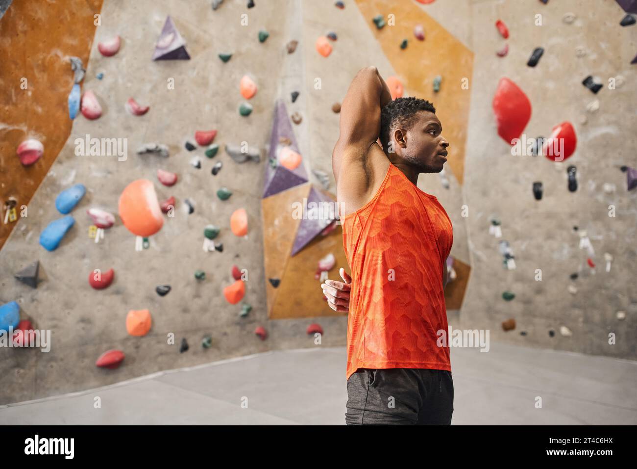 african american athletic man in orange shirt warming up with hands ...