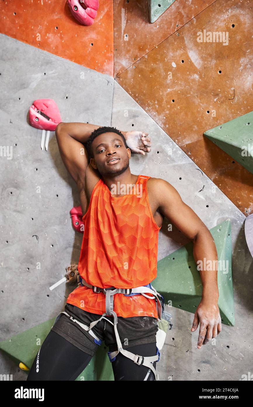 vertical shot of african american man next to climbing wall with hand ...