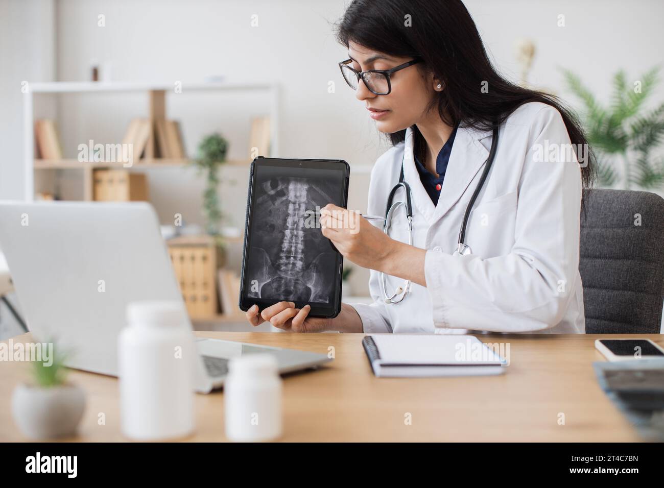 Indian female specialist sitting in front of digital laptop and ...