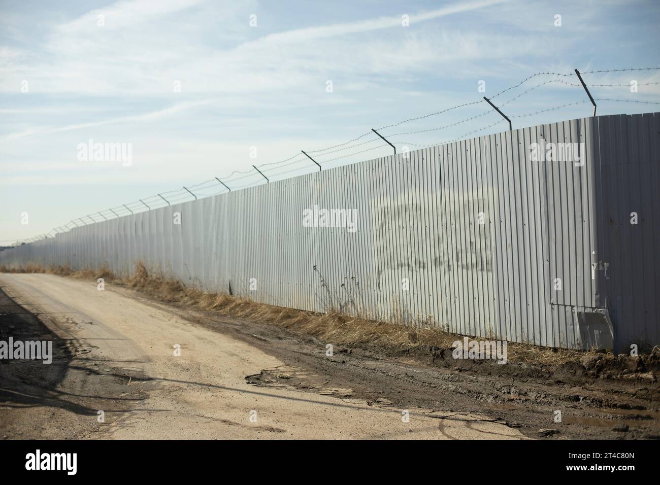 Fence in industrial zone. Road along territory. Passage between fences ...