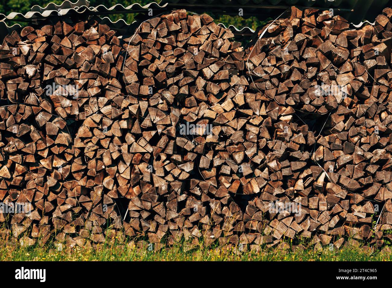 Large stack of chopped firewood on farmland drying in summer, selective ...