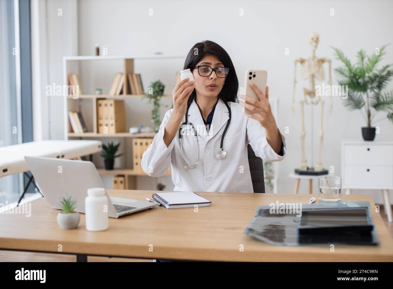 Indian female doctor having video call consultation with ill patient ...
