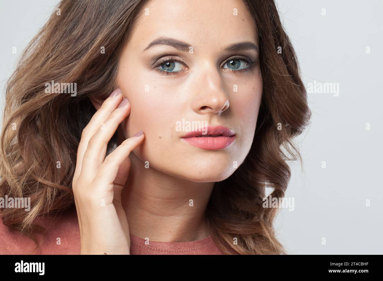 Good looking woman with clear perfect skin, makeup and wavy brown hair ...