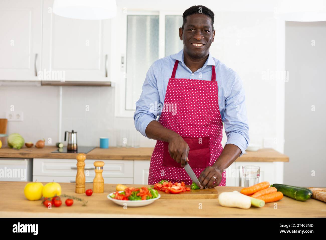Man in an apron is standing at his desk at home Stock Photo - Alamy