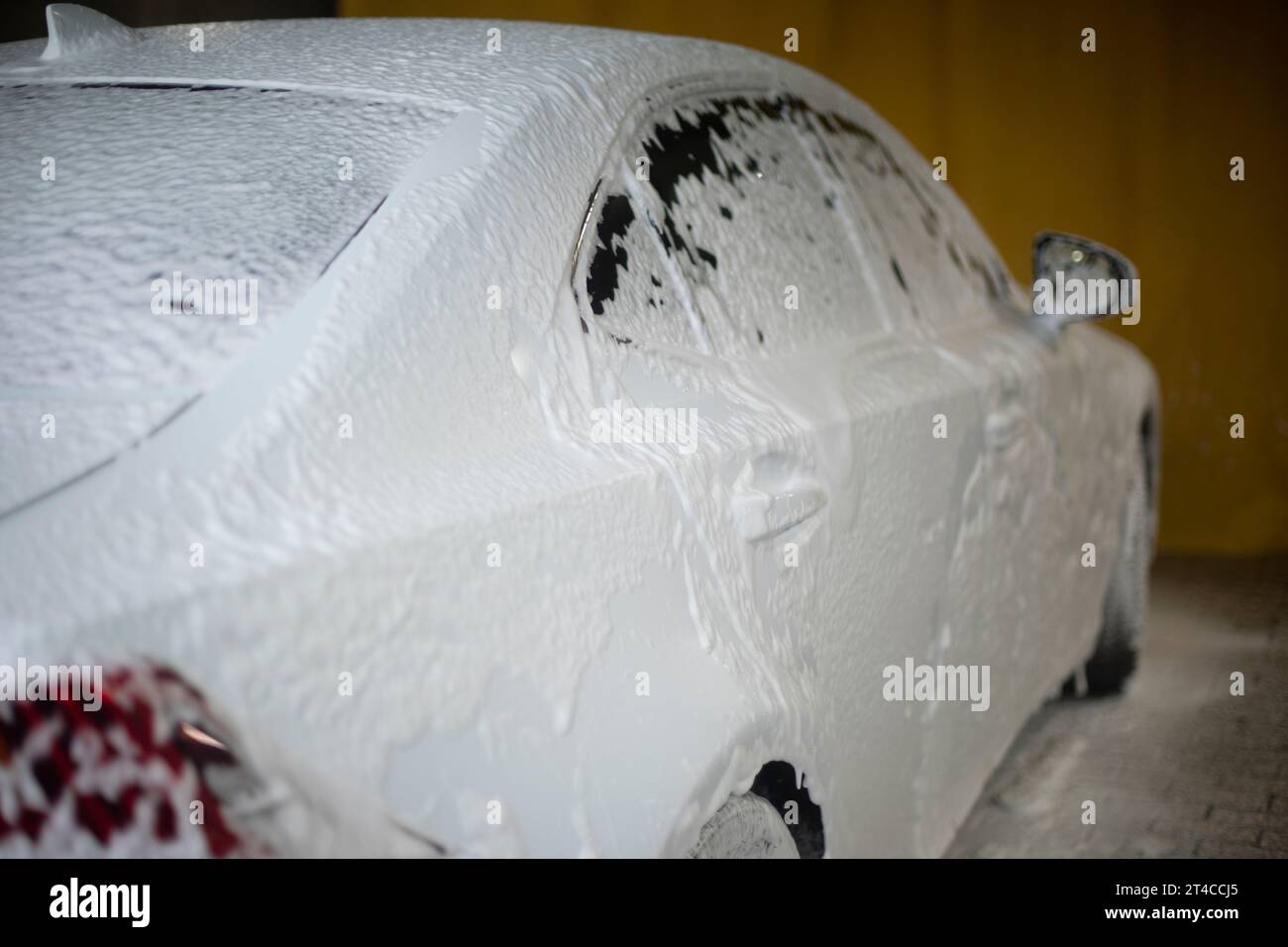 Machine in soap suds. Car wash in city. Cleaning car from dirt. White ...