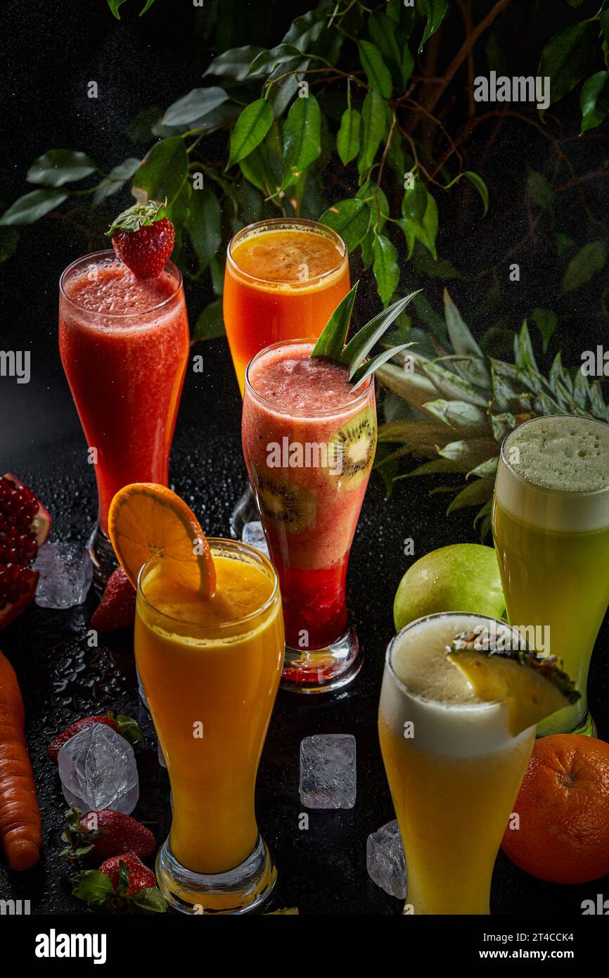 A picture of several cups of various natural juices on a black ...