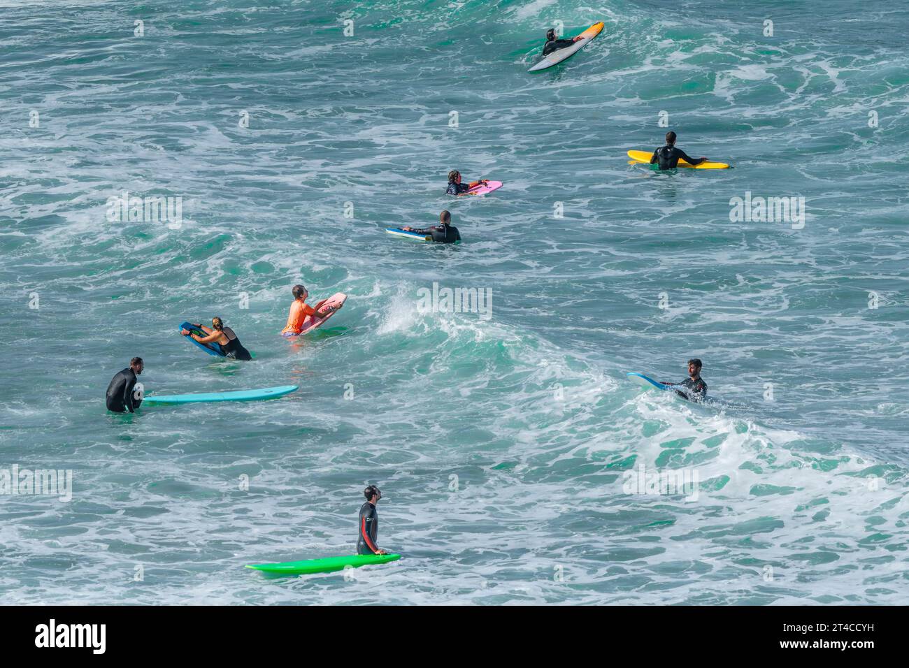 Surfers and their surfboards floating in the sea waiting for a wave in ...