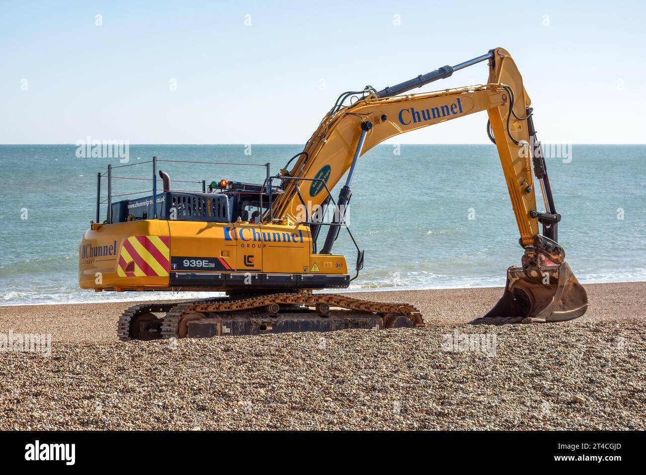Large scale construction excavator replenishing the sea defences on ...