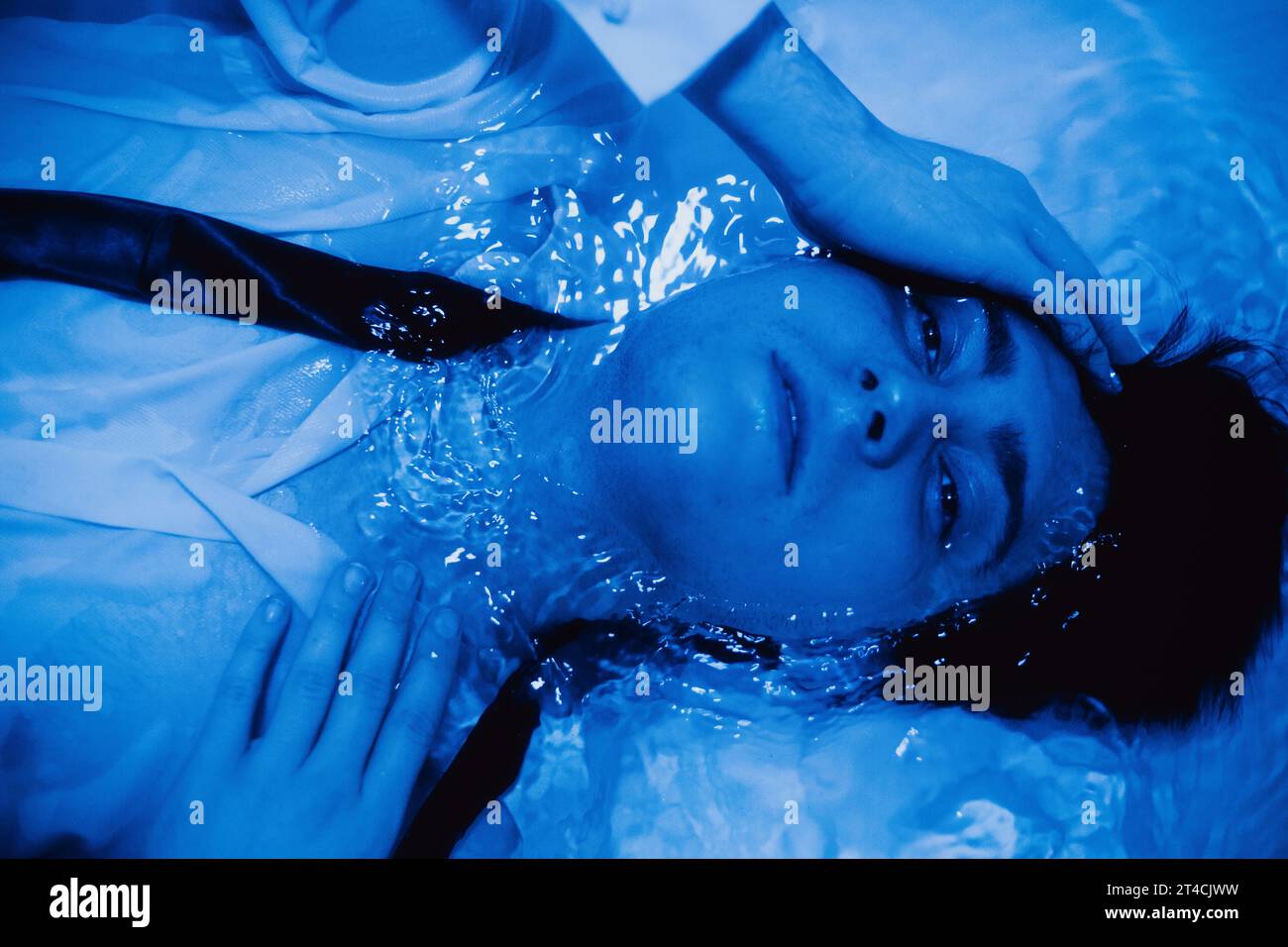 In the darkness of the night, a young, handsome man, clad in a wet ...