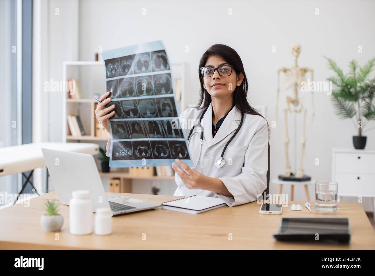 Nurse studying CT brain scans in doctor's office interior Stock Photo ...