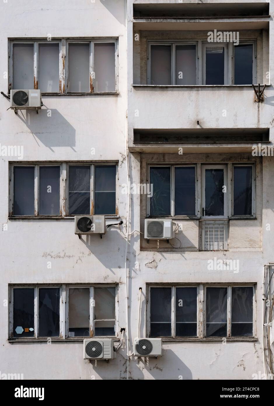 Weathered concrete building with multiple air conditioning units on the ...