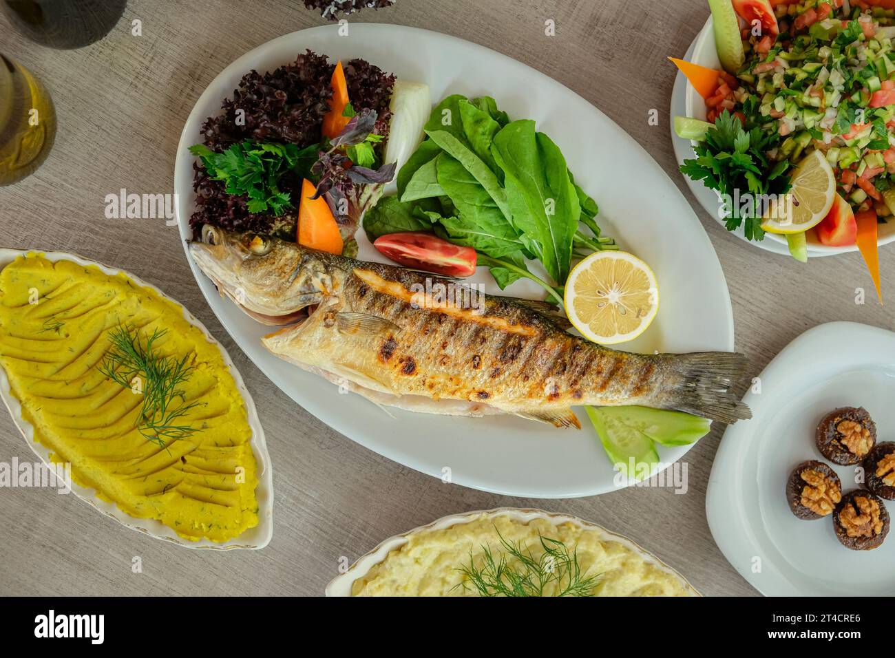 A picture from above of a table with dishes of fish and seafood ...