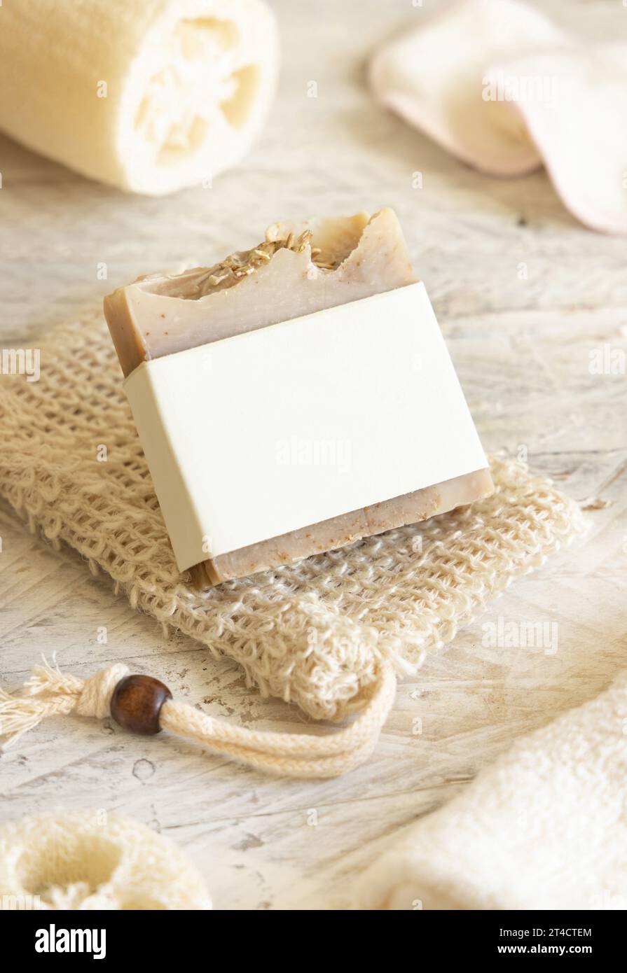 Beige handmade soap bar with blank label on soap saver bag on wooden ...