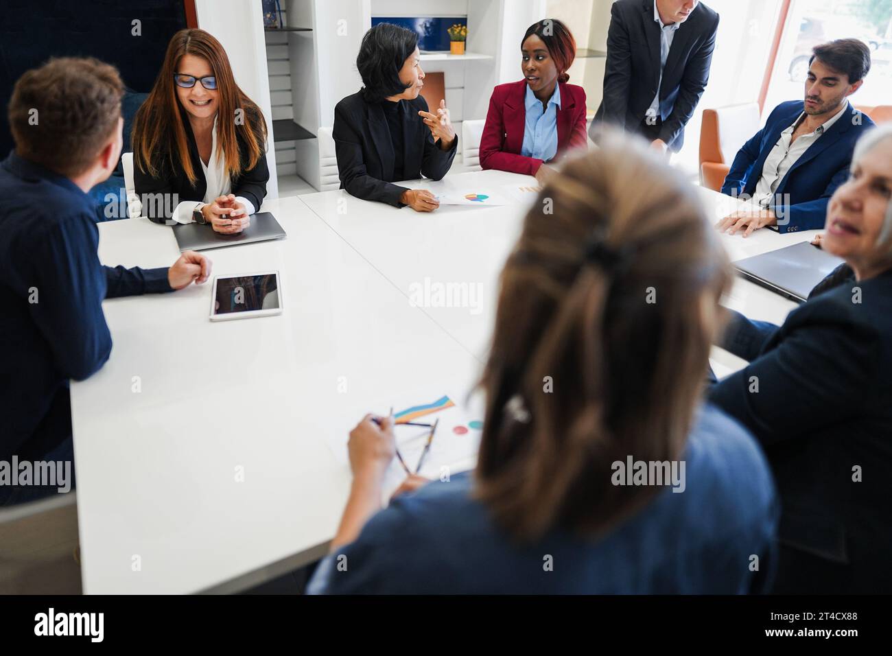 Multigenerational colleagues working inside business office ...