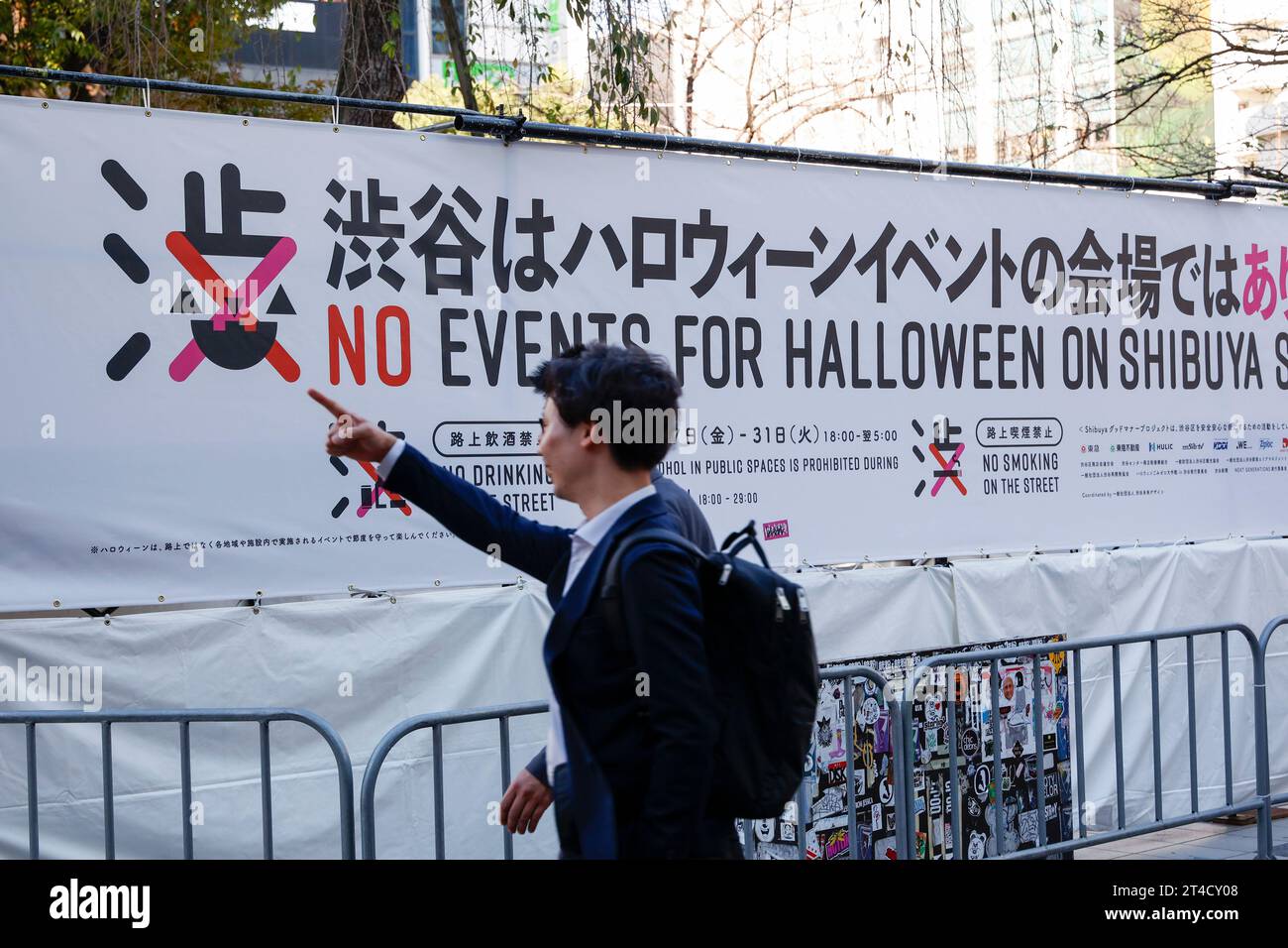 Tokyo, Japan. 30th Oct, 2023. A man walks past a signboard prohibiting ...