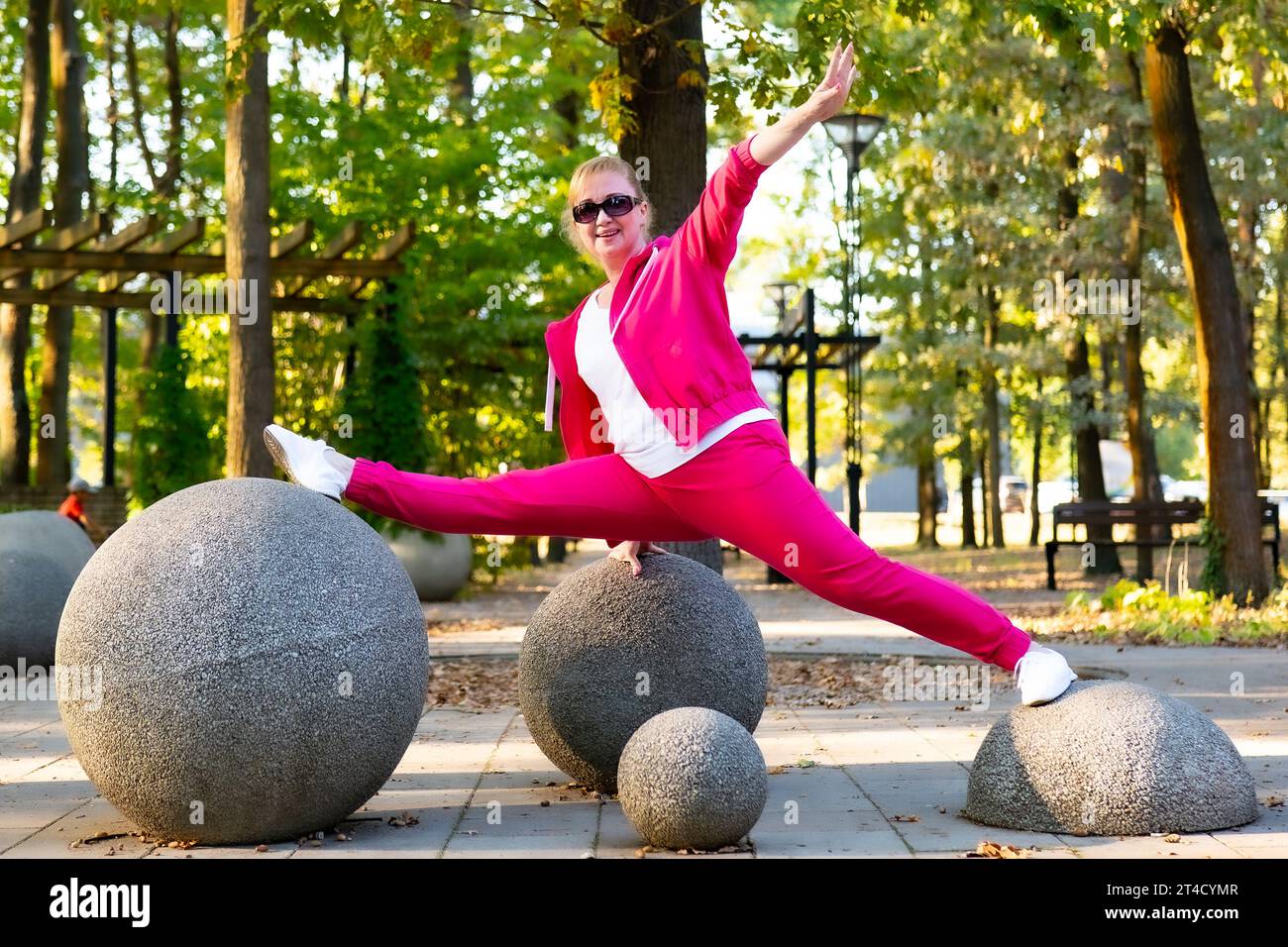 Adult woman practices gymnastics in the park, splits Stock Photo - Alamy