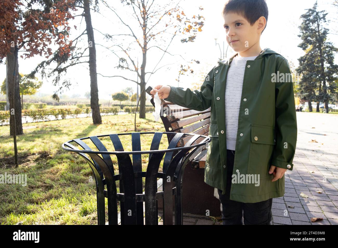A small child throws wet wipe trash into the trash bin. Garbage sorting ...