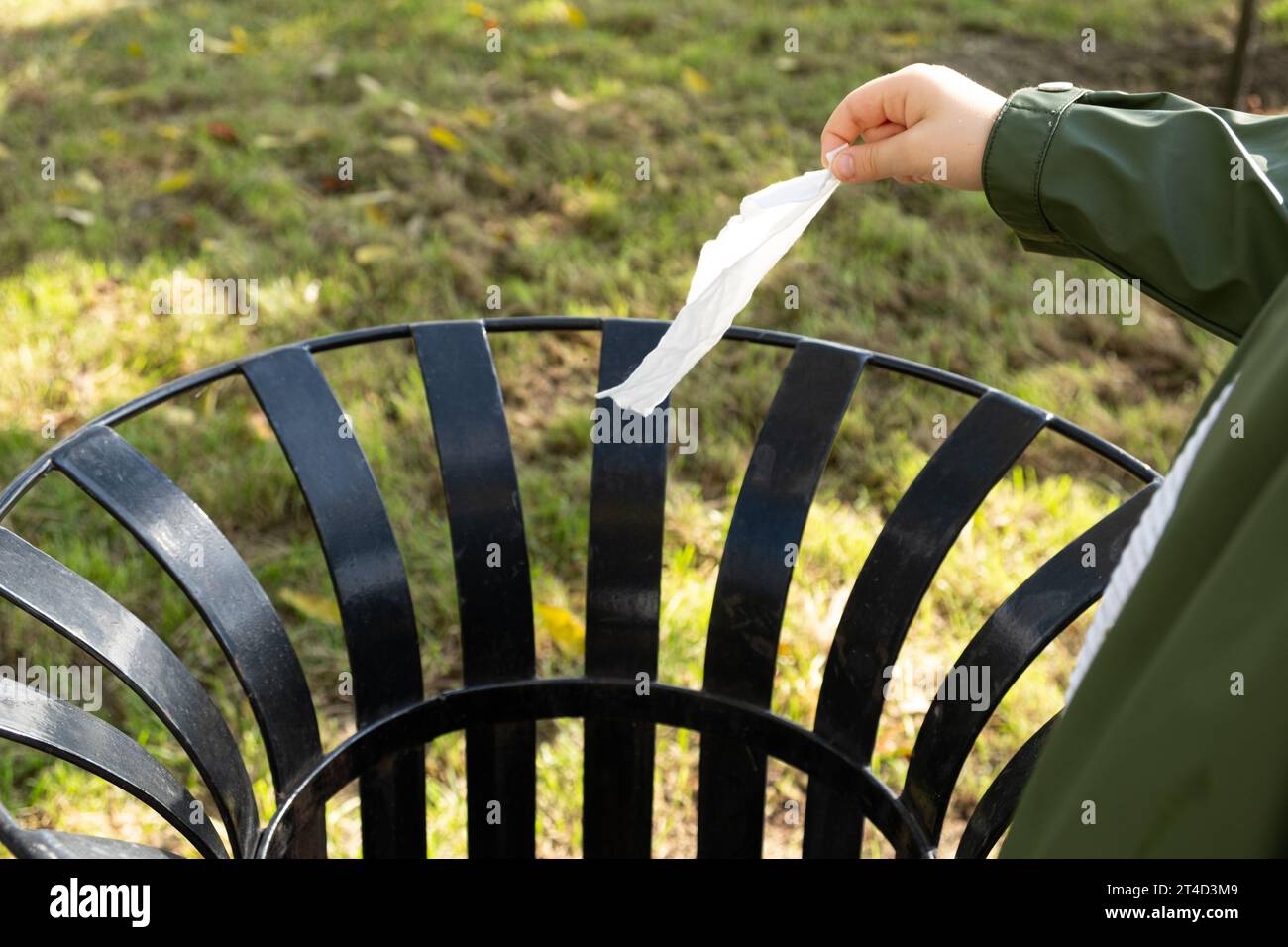 A small child throws wet wipe trash into the trash bin. Garbage sorting ...