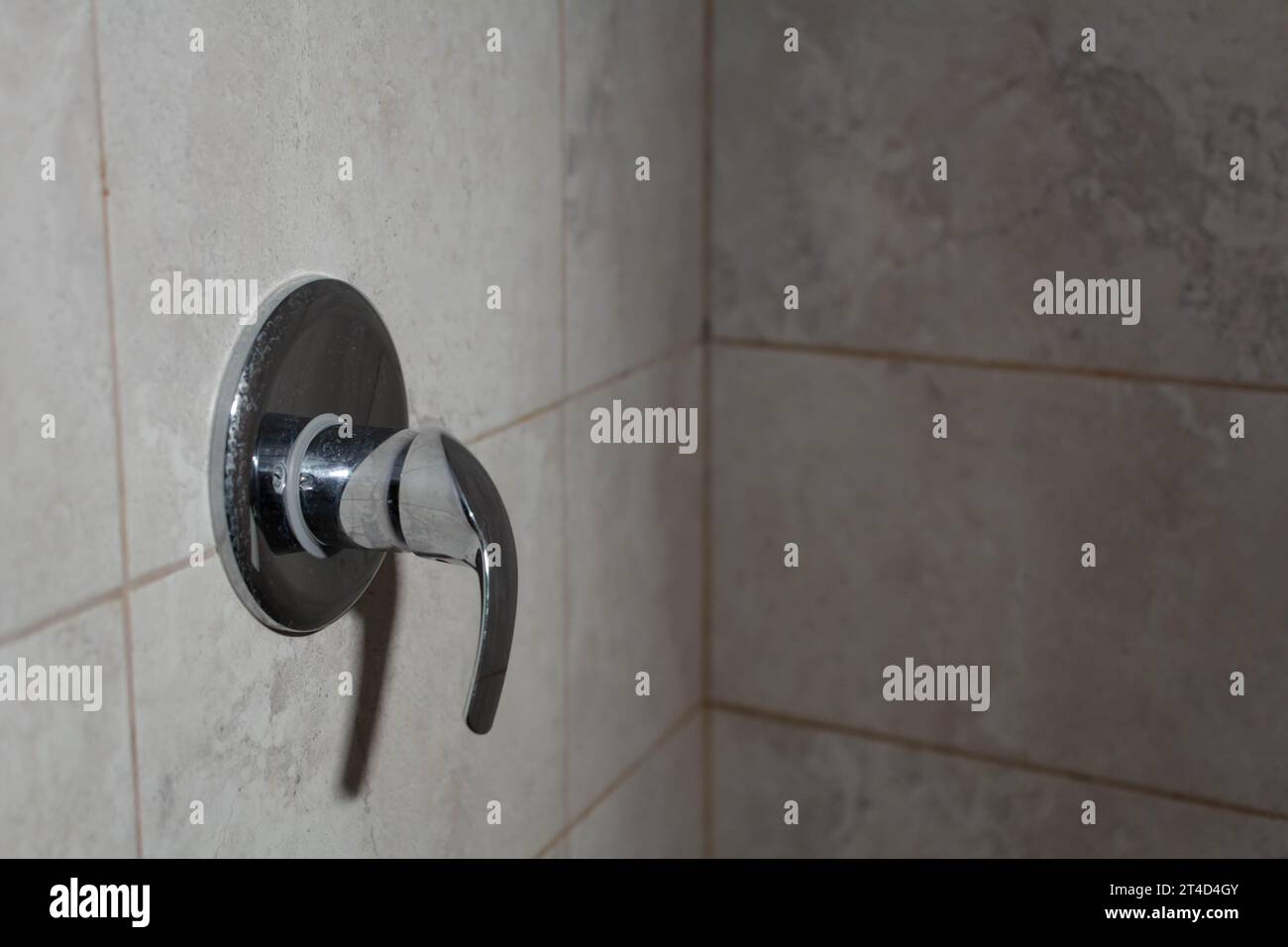 Limescale deposits on the water control handle in the shower. Selective ...