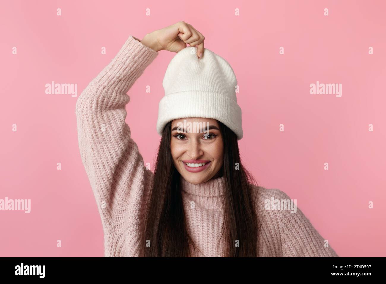 funny woman in white hat, sweater grimacing with lips on pastel pink ...