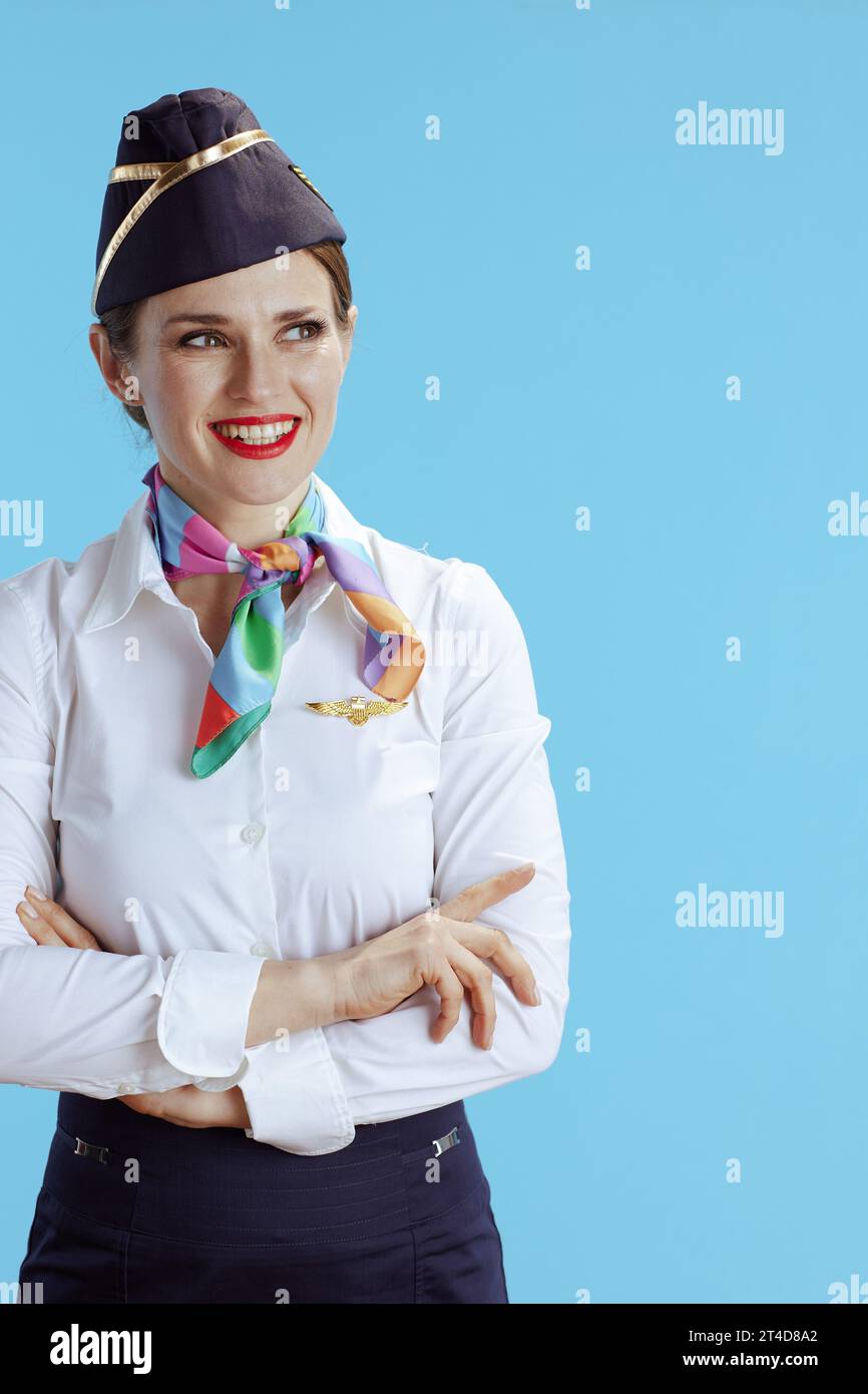 smiling elegant flight attendant woman on blue background in uniform ...