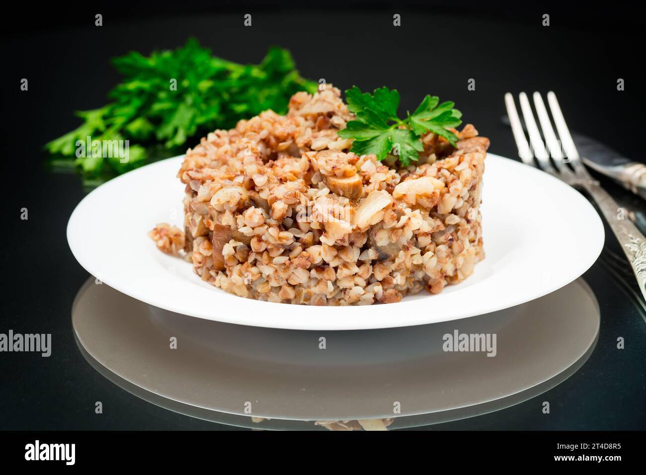 cooked buckwheat boiled with mushroom filling in a plate isolated on a ...