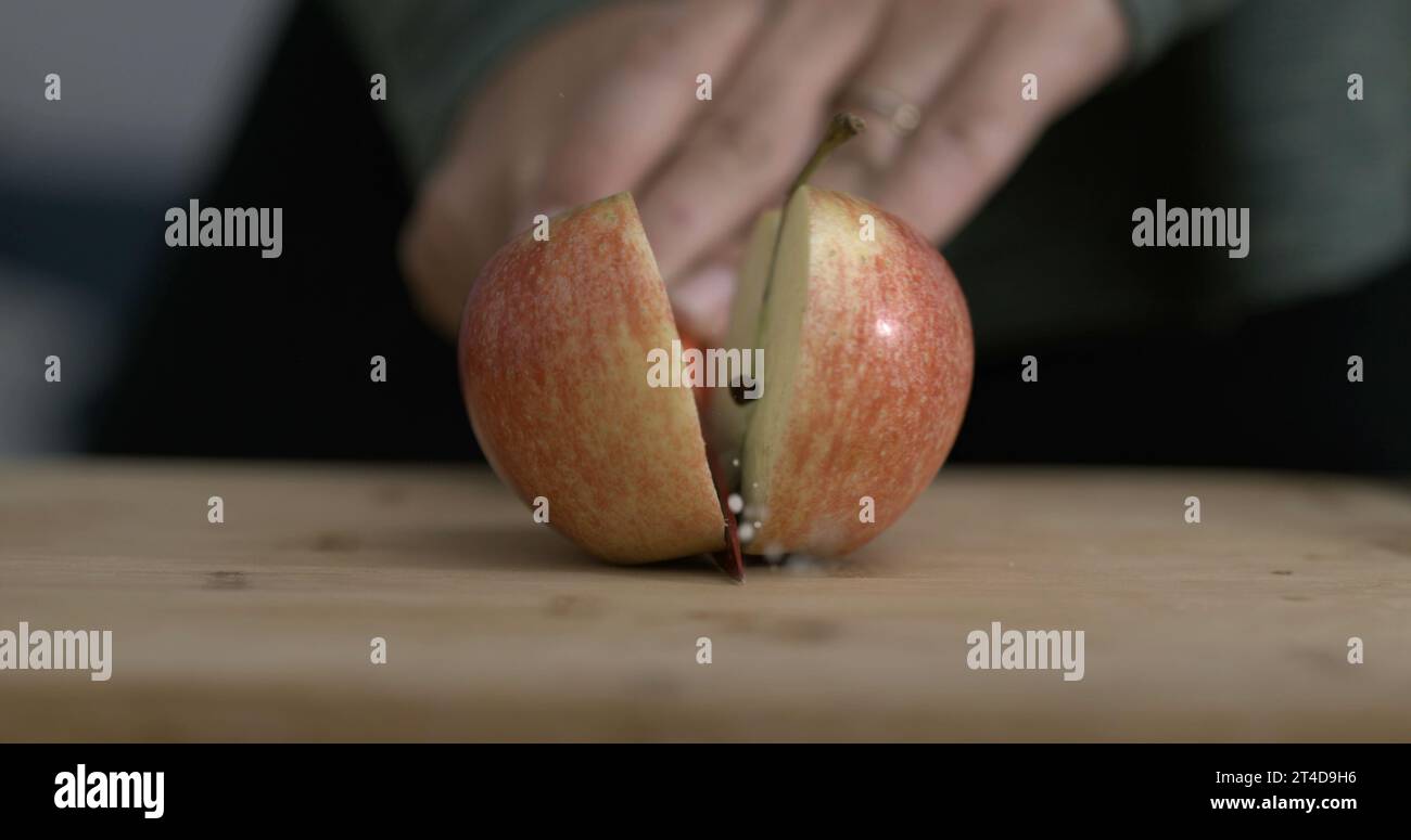Slicing an apple fuit in half with knife captured in camera Stock Photo ...