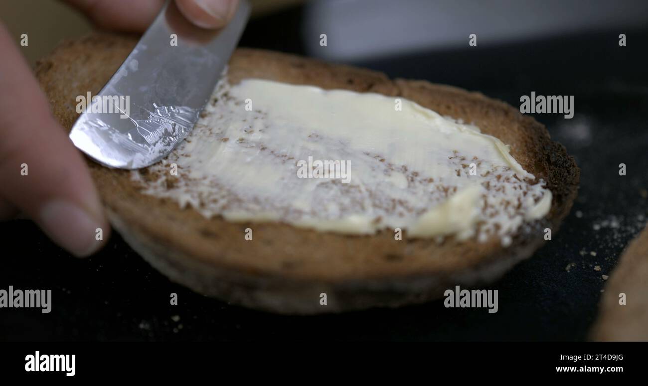 Spreading butter into toast bread in speed-ramp Stock Photo - Alamy
