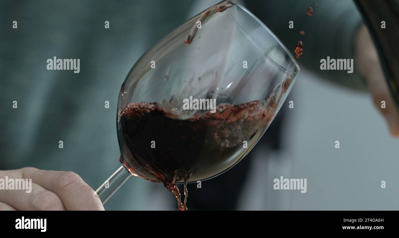 Accidental mishap of person serving wine into glass by mistake, failure ...