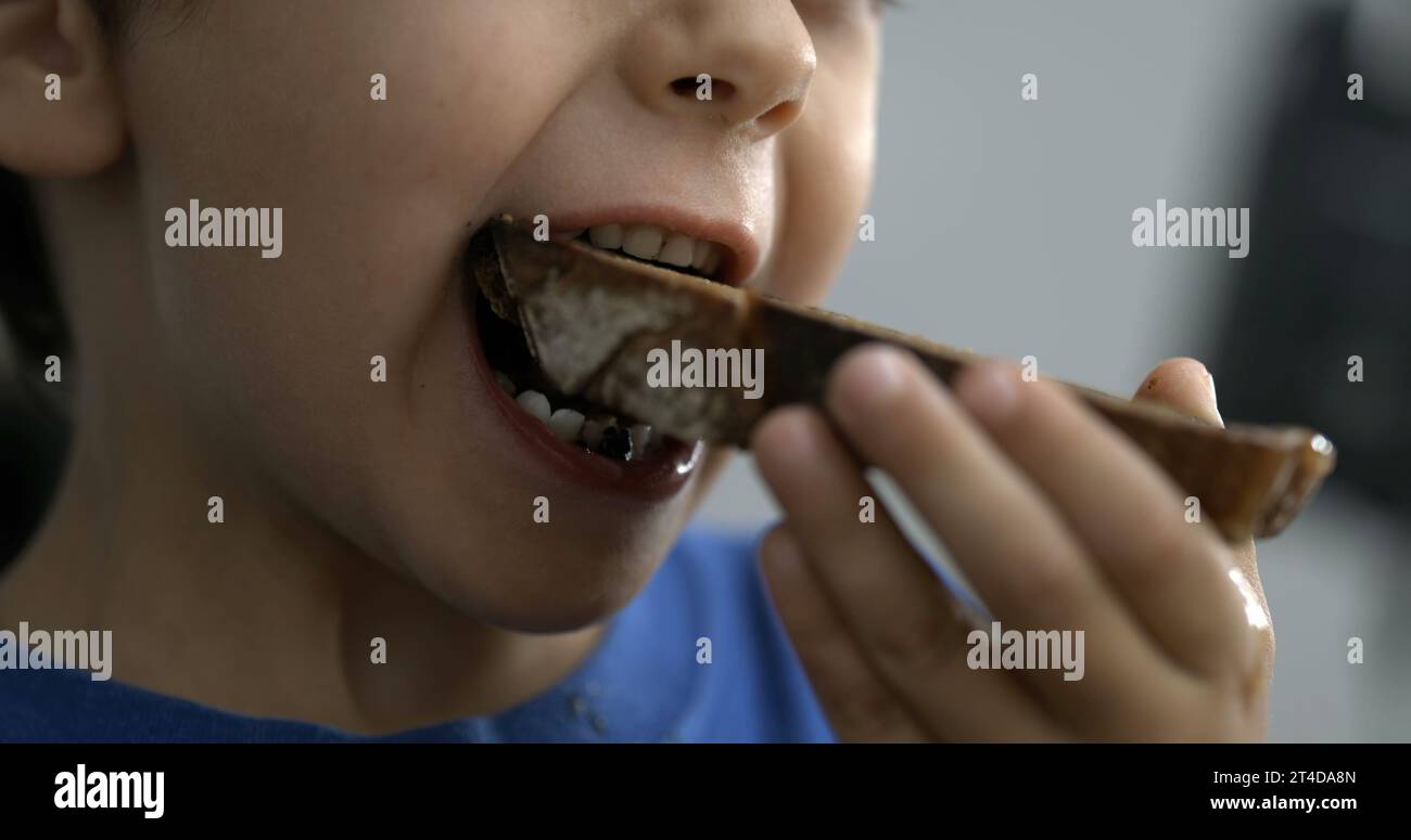 Child Close-Up mouth - Taking a Bite from Toast . Small boy eating carb ...