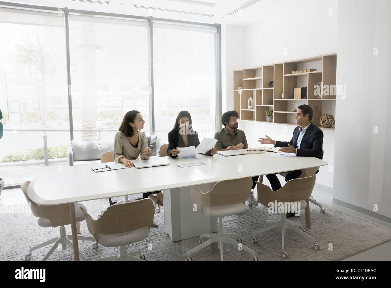 Multiethnic business team of four brainstorming in meeting room Stock ...