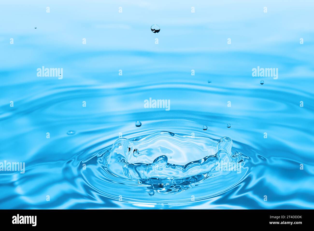 Clear aqua water droplet splashing in concentric circles, capturing ...