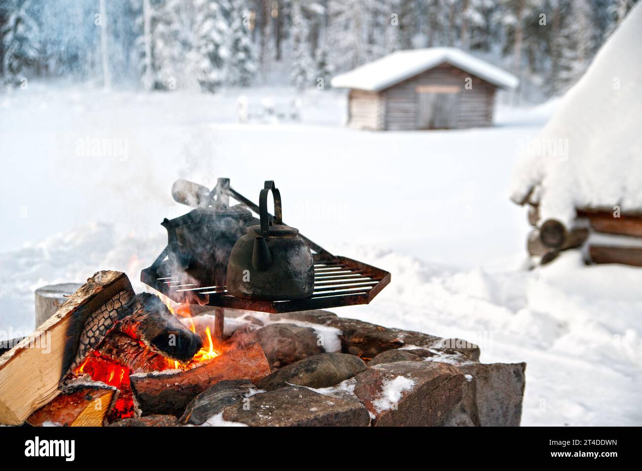 Coffee maker over open fire in winter landscape Stock Photo - Alamy