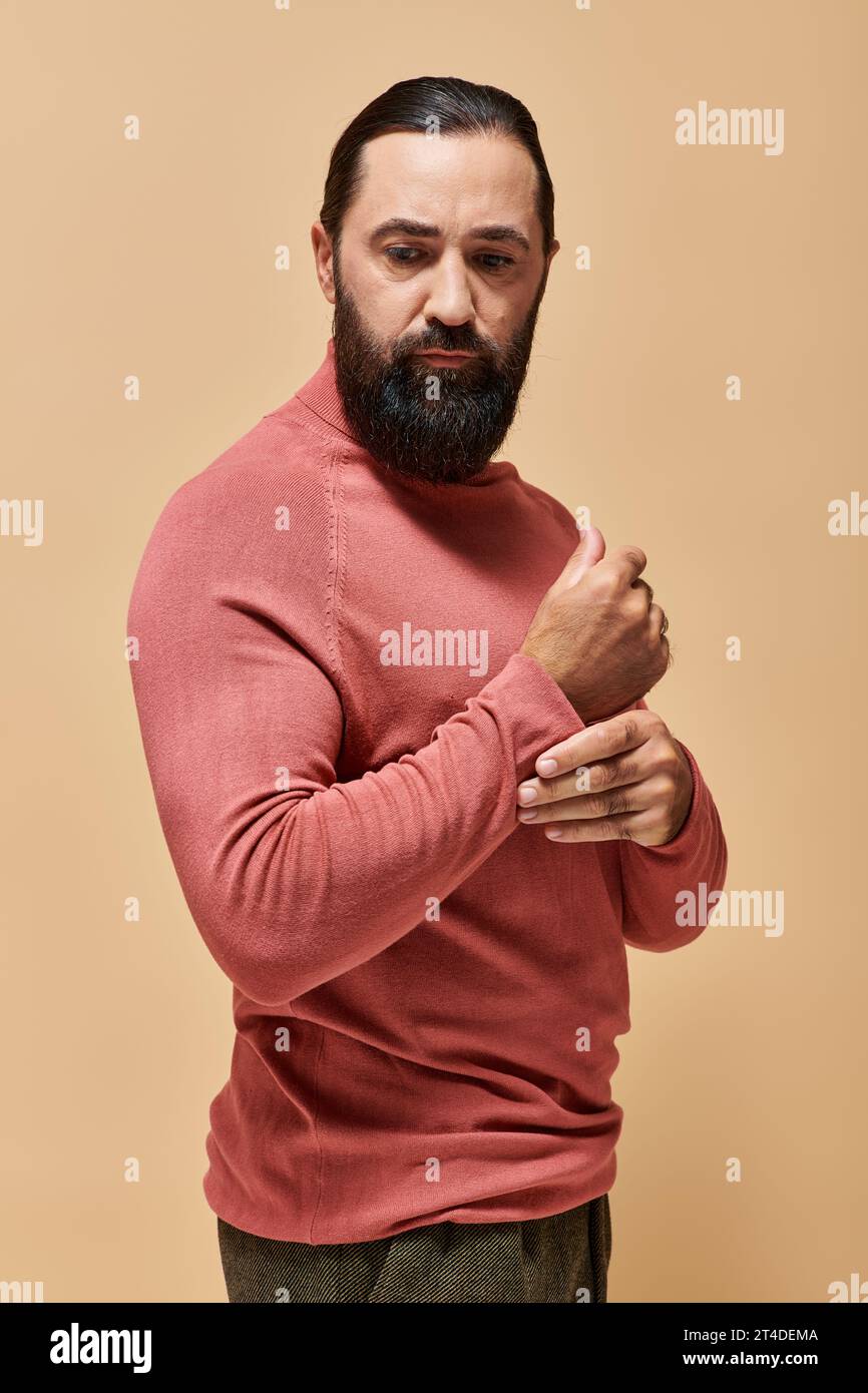 serious good looking man with beard posing in pink turtleneck jumper on ...