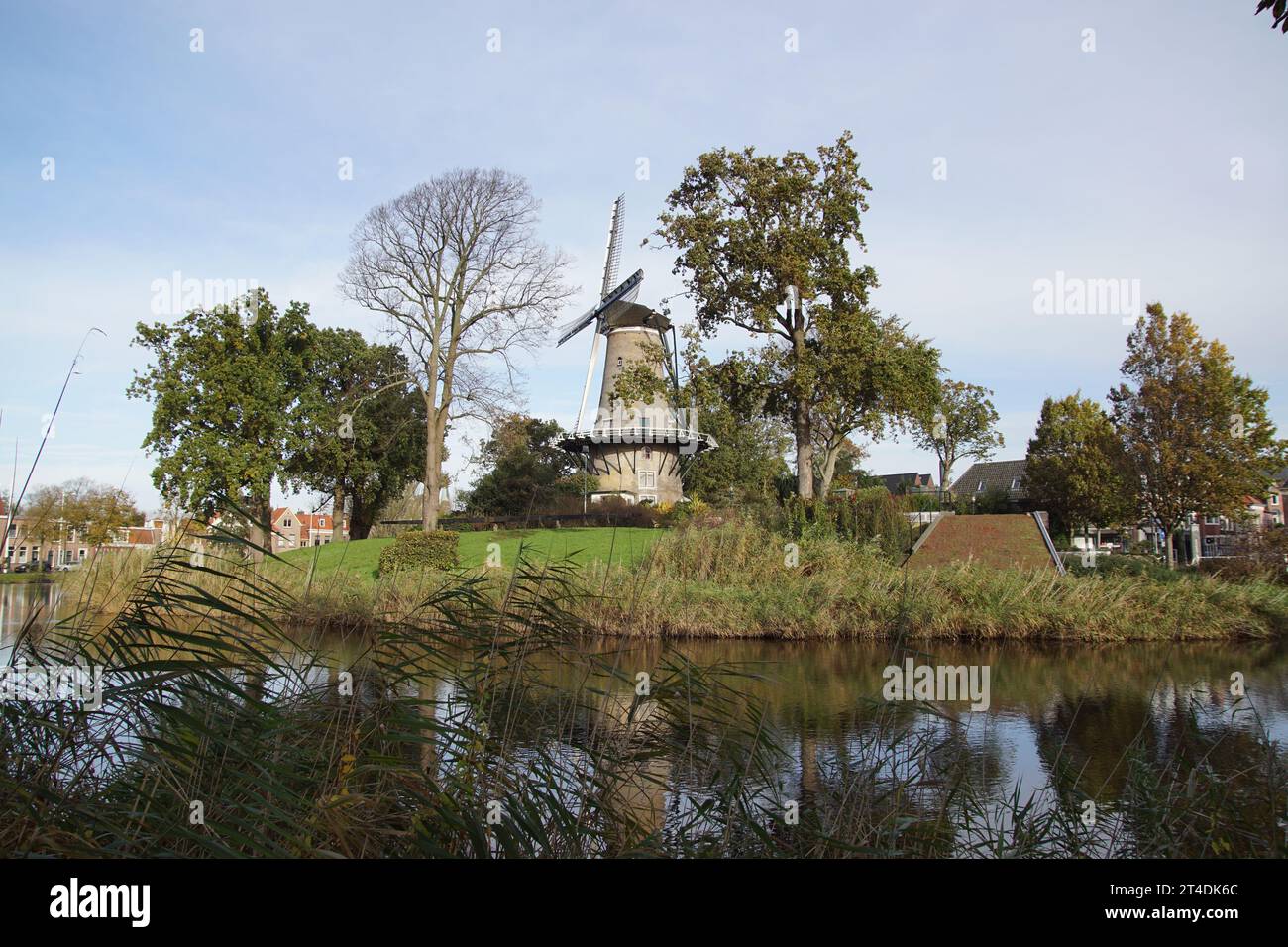 High old brick windmill on a defensive wall and canal of the Dutch city ...