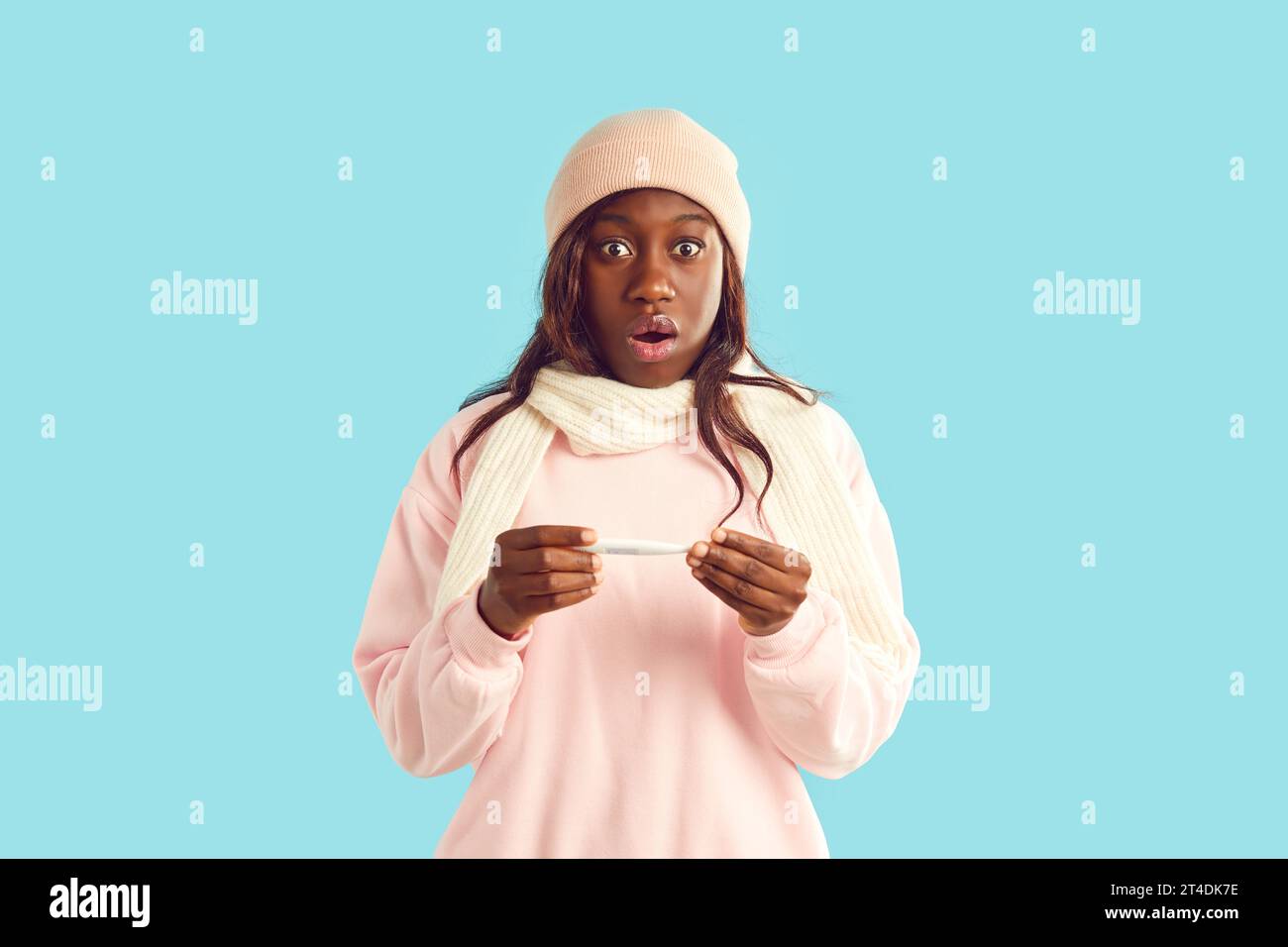 Young surprised shocked woman taking temperature standing isolated on ...