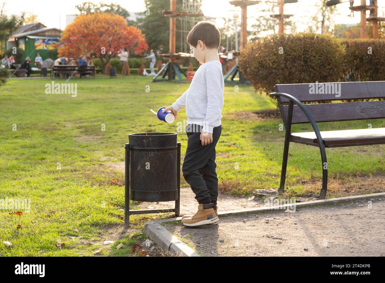 A child throws a plastic cup in the trash. Garbage recycling and ...
