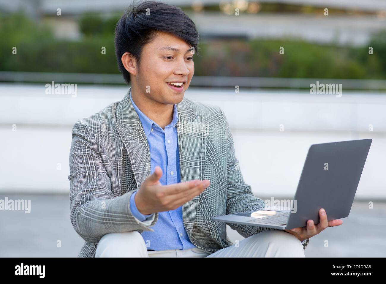 Korean business guy engaged in video call on computer outdoor Stock ...