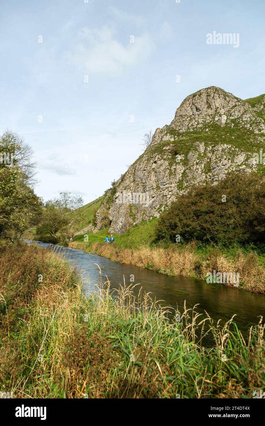 Walkers walking along the River Dove in Dovedale Valley Peak District ...